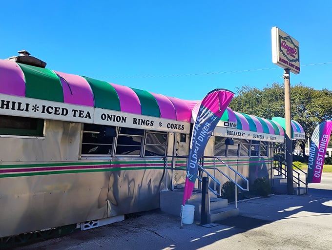 The pink and green striped awning of Angel's Dining Car isn't just eye-catching—it's a beacon of hope for hungry travelers seeking authentic diner magic in Palatka.