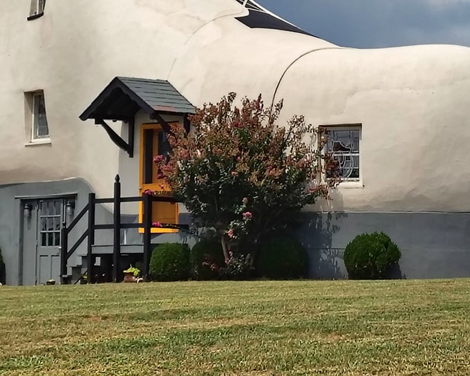 Someone decided a giant shoe needed a fence, because apparently even architectural oddities need good neighbors.