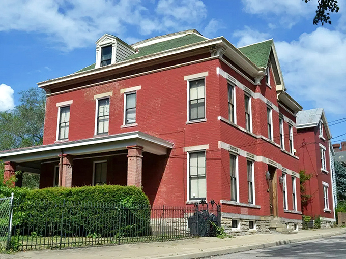 The crimson brick exterior of Sedamsville Rectory stands defiantly against the blue sky, like a Victorian-era movie set waiting for its ghost story to unfold.