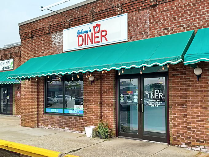 The unassuming brick exterior of Johnny's Diner in Hudson might not scream "culinary destination," but that green awning signals delicious secrets await inside.
