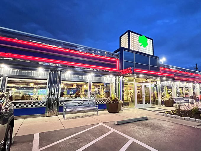 The neon-trimmed exterior of Lyndon Diner glows like a beacon for hungry travelers, its iconic green clover sign promising good luck and better breakfasts.