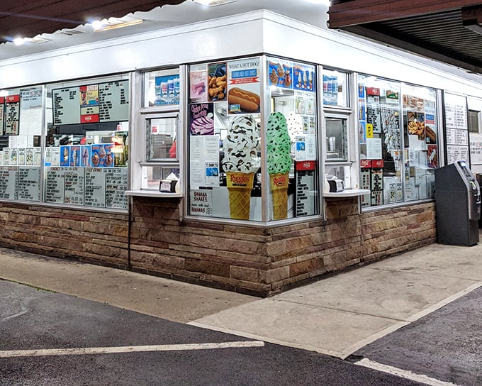 At night, the illuminated service windows transform into beacons of comfort food, promising sweet relief from the day's troubles through the universal language of ice cream.