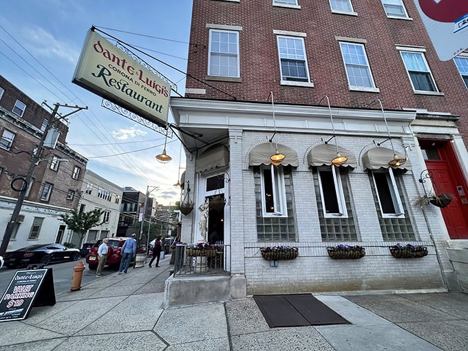 The classic white-painted brick exterior of Dante & Luigi's, with its charming awnings and hanging flower baskets, promises old-world Italian hospitality before you even step inside.