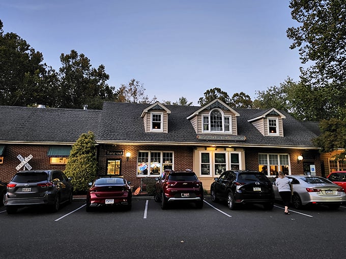 The charming Cape Cod-style exterior of Moccia's Train Stop beckons hungry travelers with its warm lights and railroad crossing sign – a delicious destination worth the journey.