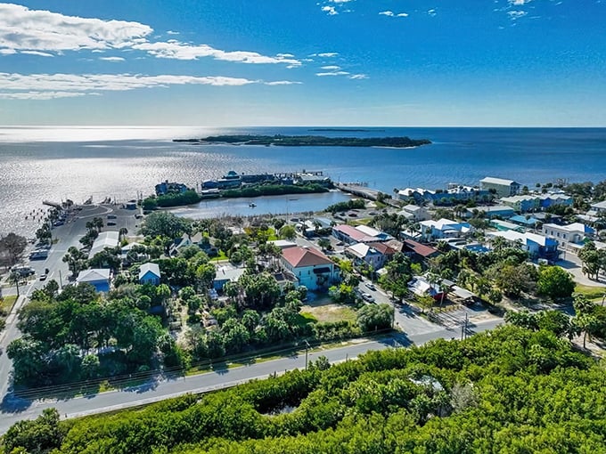 Cedar Key's aerial view reveals nature's perfect balancing act – turquoise waters meeting colorful cottages, all basking under that impossibly blue Florida sky.