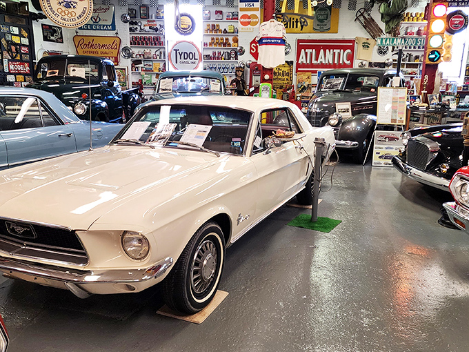 A pristine white Mustang stands guard in this automotive time capsule, where vintage signs and memorabilia create the ultimate gearhead's paradise.