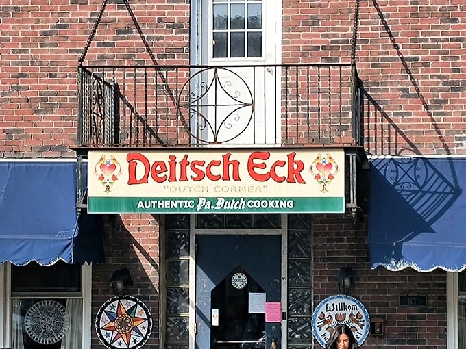 The brick facade of Deitsch Eck welcomes hungry travelers with its vibrant sign promising authentic Pennsylvania Dutch cooking—a culinary time machine disguised as a restaurant.