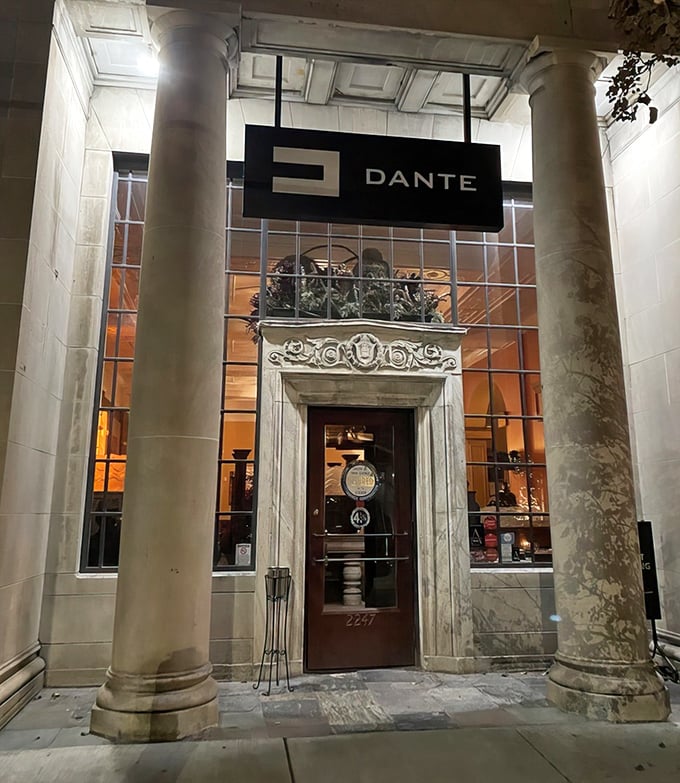 The grand entrance to Dante beckons with majestic columns and warm light, promising an Italian feast in what was once a temple of commerce.