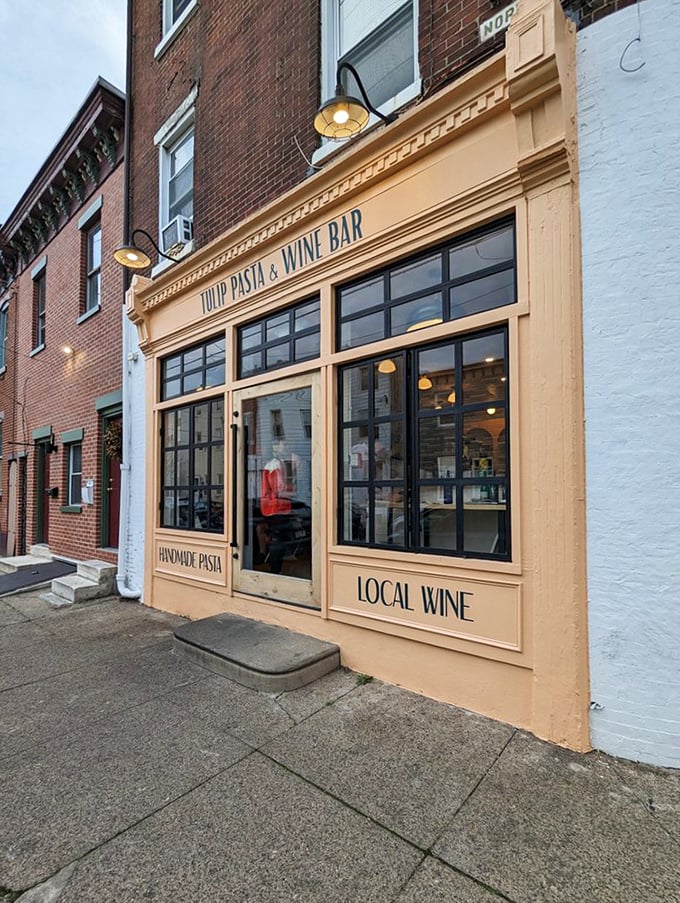 The peachy façade of Tulip Pasta & Wine Bar stands out like a culinary beacon among Philadelphia's brick buildings, promising handmade pasta treasures within.