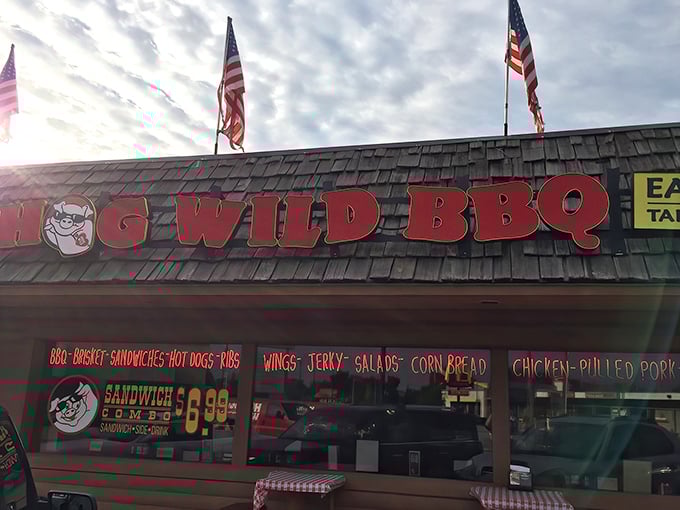Hog Wild BBQ's rustic exterior promises smoky delights beneath American flags—a carnivore's paradise hiding in plain sight in Holland.