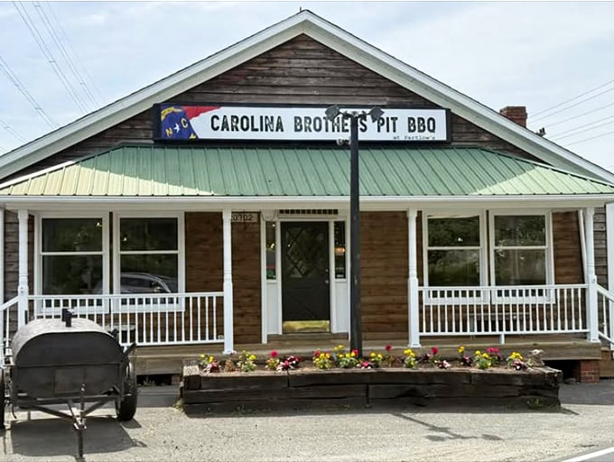 That green metal roof and white porch railing aren't just charming—they're the gateway to smoky paradise. The smoker out front is your first clue.