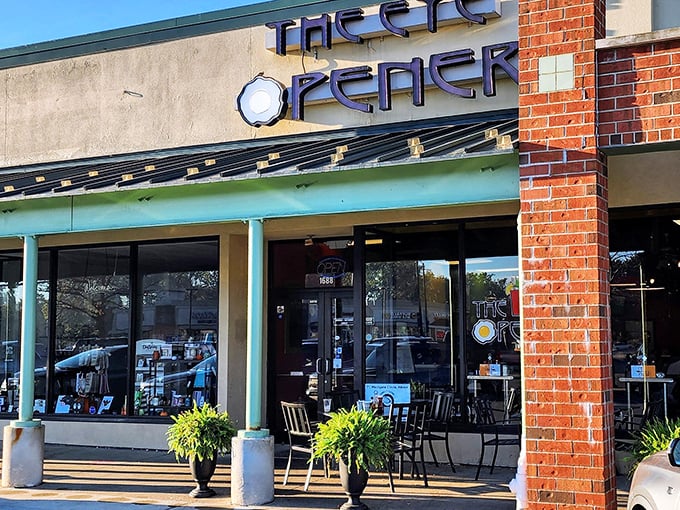 The welcoming storefront of The Eye Opener beckons with its distinctive sign and cozy patio seating—breakfast paradise awaits behind those doors.