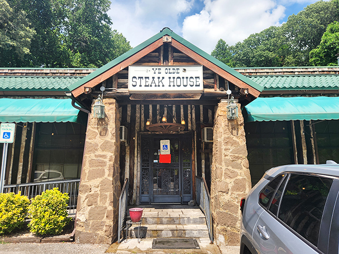 The rustic log cabin exterior with its signature green awning promises what every carnivore dreams of—a no-nonsense temple to perfectly cooked beef.
