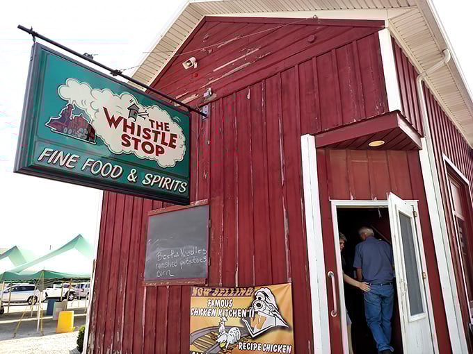 The iconic red barn exterior of The Whistle Stop beckons hungry travelers like a culinary lighthouse in Ansonia's sea of cornfields.