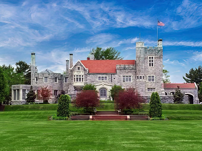 The castle's magnificent façade showcases its perfect symmetry, where gray stone meets red roof against an impossibly blue Ohio sky.