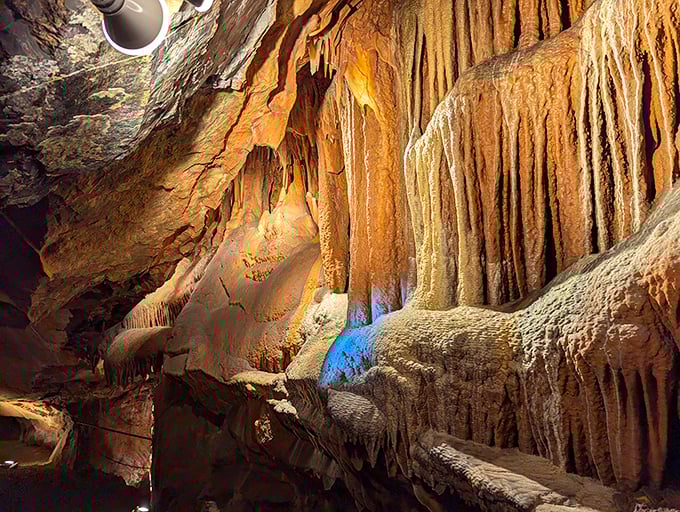Nature's own art gallery unfolds before you, with amber-hued stalactites hanging like prehistoric chandeliers in this underground wonderland.