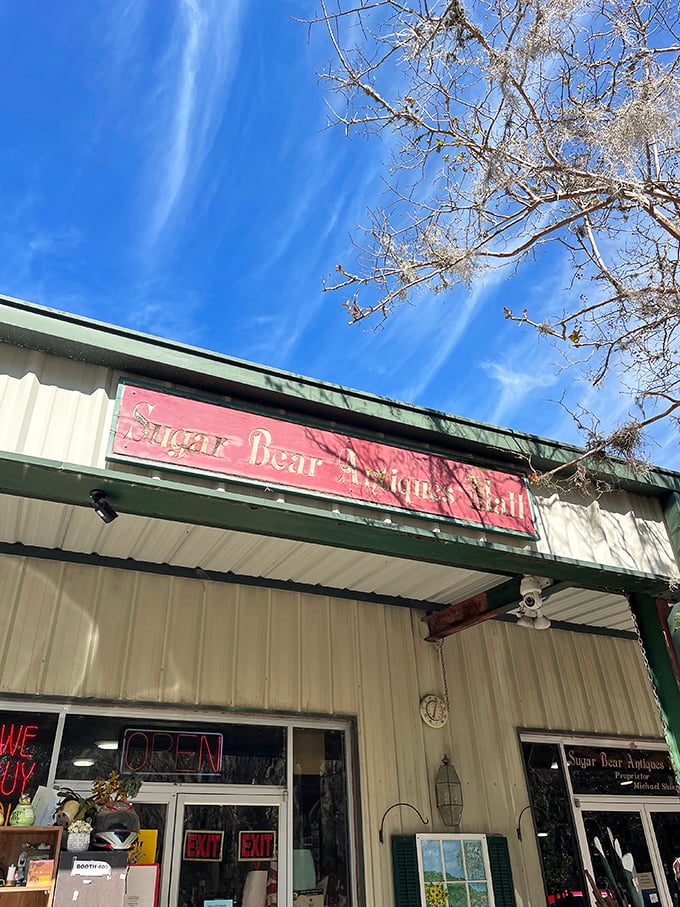 The weathered red sign against Jacksonville's blue sky promises treasures within – like finding a portal to the past hiding in plain sight.