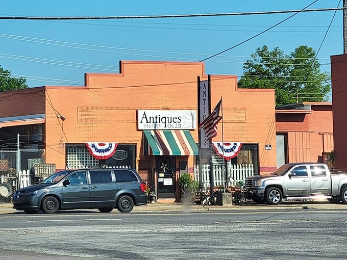 The brick-red facade with its candy-striped awning isn't just inviting—it's practically shouting "Come in and find your next conversation piece!"