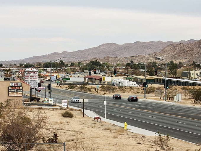 Highway 62 cuts through Joshua Tree like a lifeline, connecting quirky shops and desert dreams under the watchful gaze of ancient mountains.