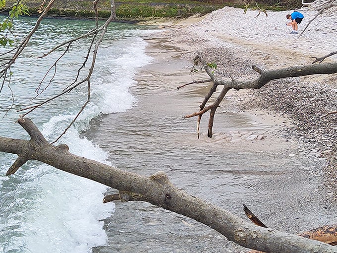 Two beachcombers enjoy Lake Erie's gentle waves on Kelleys Island's distinctive stone beach—nature's own meditation spot where skipping stones is practically an Olympic sport.