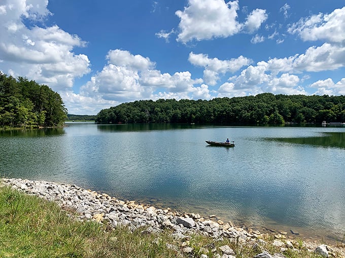 A lone fisherman finds solitude on Fall Creek Falls Lake, where the boundary between water and sky blurs into a perfect Tennessee afternoon.