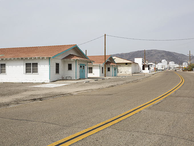 Desert living at its most authentic—modest homes stand sentinel against the dramatic backdrop of mountains that frame this resilient mining community.