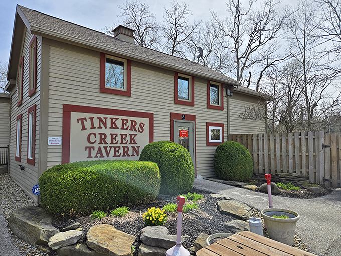 Perfectly manicured shrubs frame this charming tavern, where the sign boldly announces what locals already know – you've found a hidden gem.