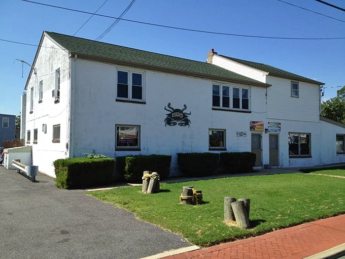 The unassuming white exterior of Kelly's Tavern in Port Penn might fool you, but that crab sign? That's nature's way of saying "treasure inside."