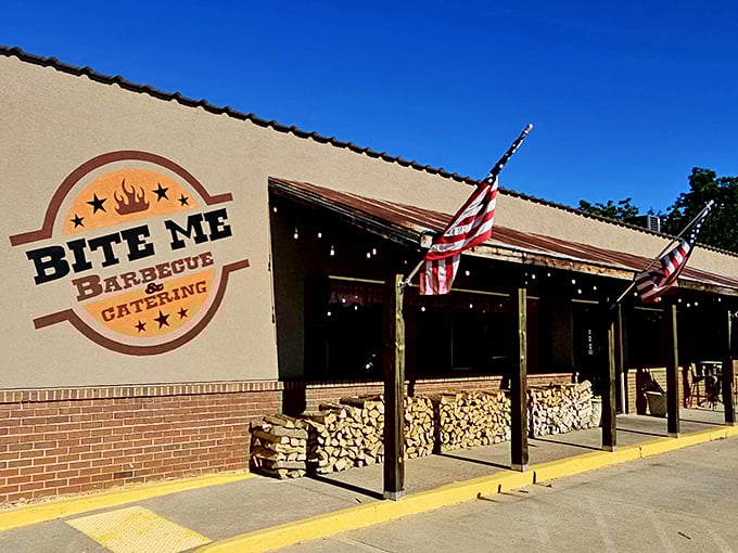The humble exterior of Bite Me Barbecue promises no frills, just thrills. Those stacked wood logs aren't just decoration—they're a preview of smoky delights to come.