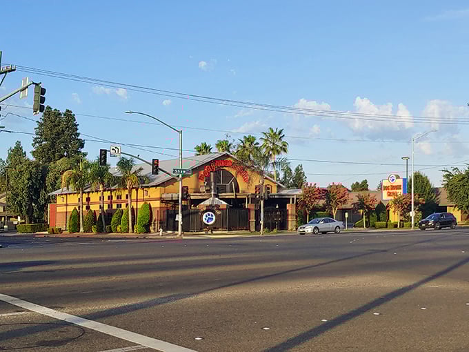 A California sunset casts a golden glow on Dog House Grill's exterior, where palm trees and promise of perfect tri-tip sandwiches await.
