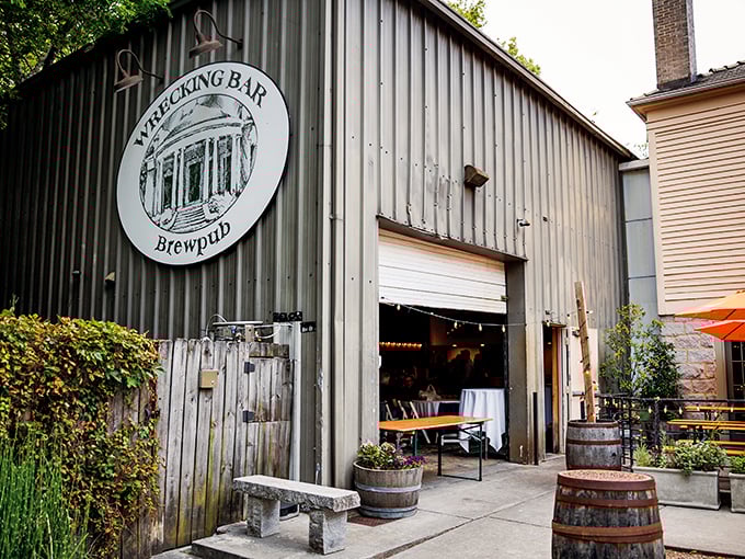 Industrial meets historic at the brewpub's entrance, where wooden barrels and stone benches invite you to slow down before the flavor marathon begins.