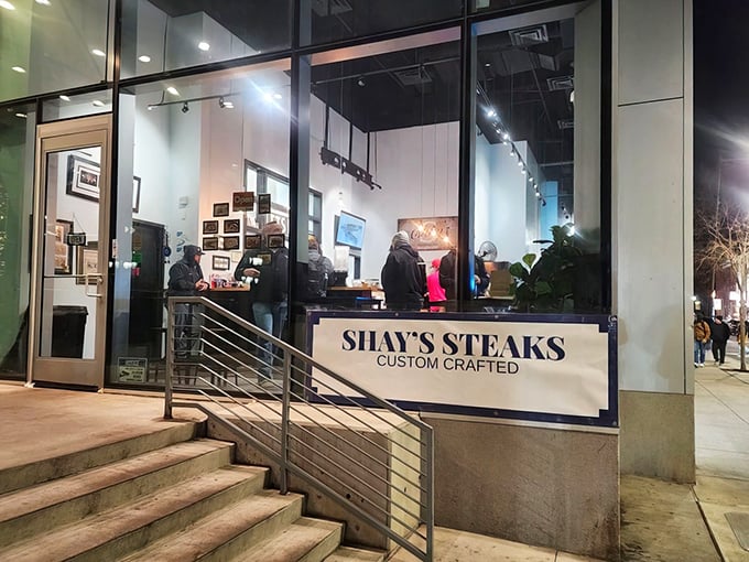 Shay's Steaks gleams like a modern oasis amid Philadelphia's urban landscape, its sleek glass storefront promising culinary treasures within.
