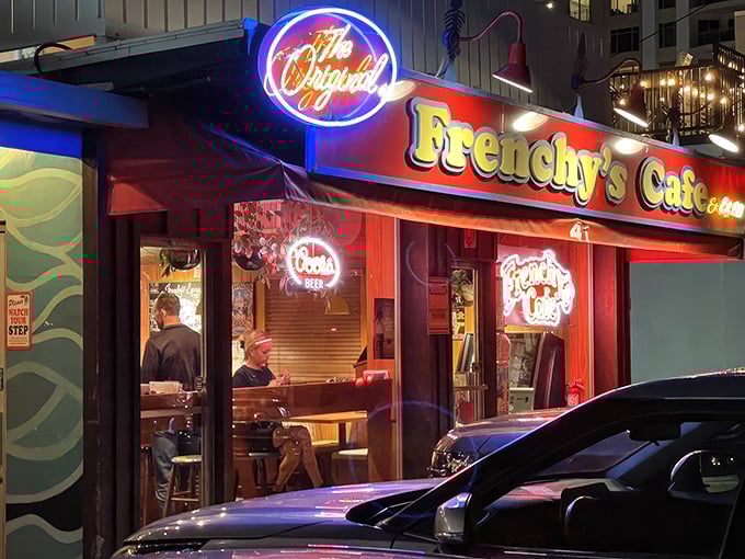 The iconic neon glow of Frenchy's Original Cafe beckons seafood lovers to Clearwater's legendary grouper haven after sunset.