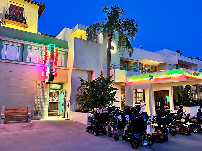 The neon-bright exterior of 50's Prime Time Café stands as a technicolor beacon of nostalgia amid the Florida palms. Mom's kitchen never looked this inviting from the outside.