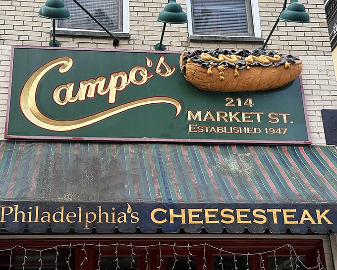 Campo's iconic blue awning and vintage signage stand as a beacon of sandwich perfection in Philadelphia's historic district, promising authentic cheesesteak bliss since 1947.