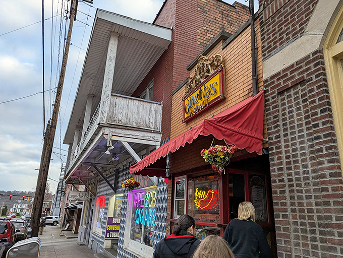 The red awning beckons like a culinary lighthouse on Athens' brick-lined street. This tiny storefront promises big flavors behind that neon hot dog sign.