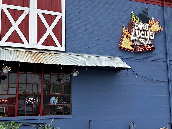 The bright blue exterior of Sweet Lucy's stands out like a delicious mirage, promising smoky treasures within those barn-inspired walls.