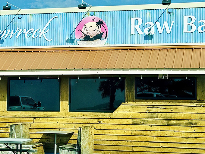 The weathered wooden exterior and bright blue corrugated metal isn't trying to impress you—it's saving all that energy for what's on your plate.