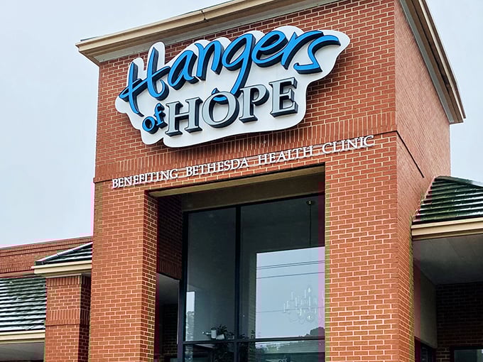The bright blue Hangers of Hope sign against brick promises more than just retail therapy—it's shopping with a side of soul.