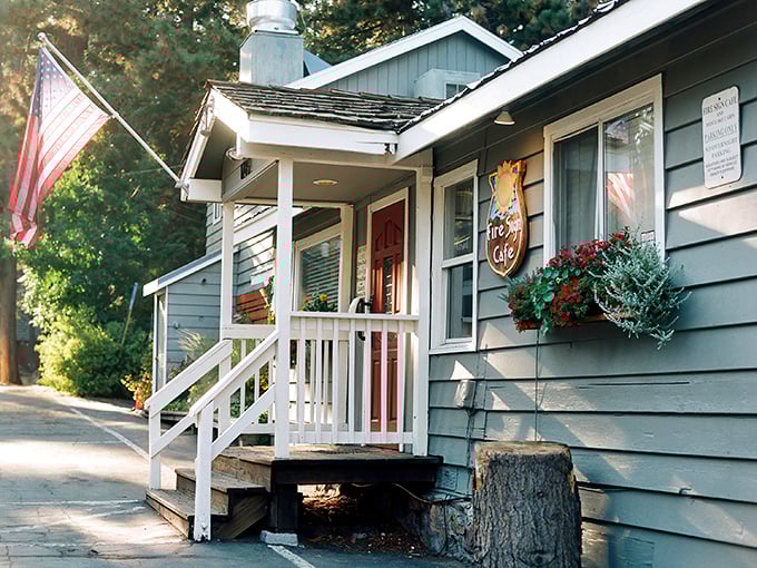 The quintessential Tahoe hideaway – a blue cabin nestled among pines, complete with white porch and American flag. Breakfast paradise awaits!