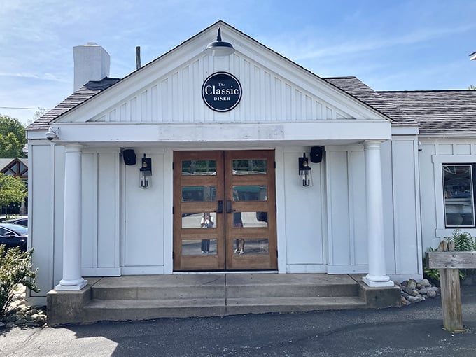 The white clapboard exterior with those welcoming wooden doors isn't trying to be fancy—it's promising something better: breakfast perfection waiting inside.