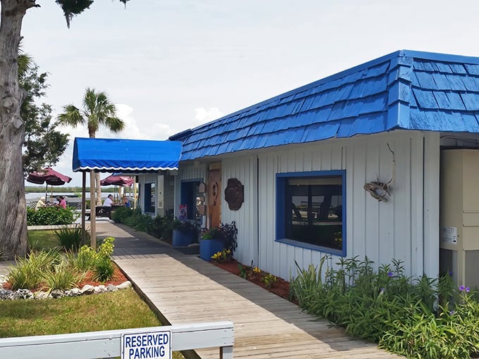 The wooden boardwalk leading to Peck's Old Port Cove feels like the entrance to a secret seafood society. Blue roof, white walls, and Florida sunshine—perfection awaits.