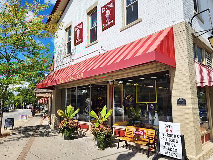 That iconic red awning isn't just a sunshade—it's a time portal to an era when conversations happened face-to-face and milkshakes required both hands.