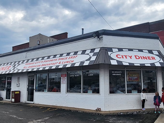 The classic black and white checkerboard trim frames City Diner's bold red signage like a culinary chess match where everyone wins—especially your appetite.