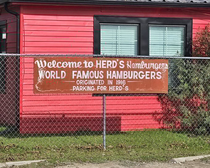 The iconic red exterior of Herd's Burgers stands as a beacon of burger perfection in Jacksboro, where that faded sign promises more than just a meal—it's a time machine to 1916.