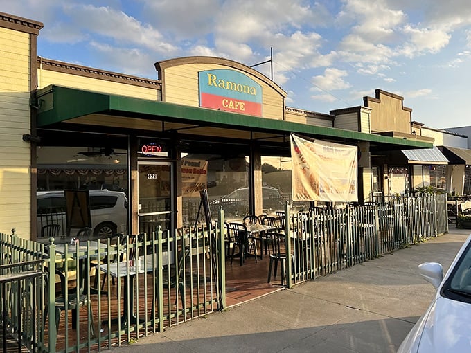 The unassuming exterior of Ramona Cafe, where that famous sign promising half-pound cinnamon rolls is your first clue that calorie-counting stops here.