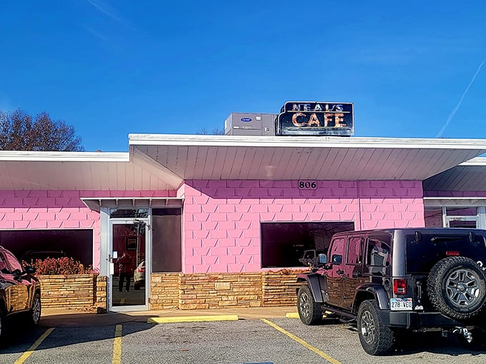 That iconic pink facade with the classic Neal's Cafe sign overhead—like a beacon calling hungry travelers home to Springdale's beloved dining institution.