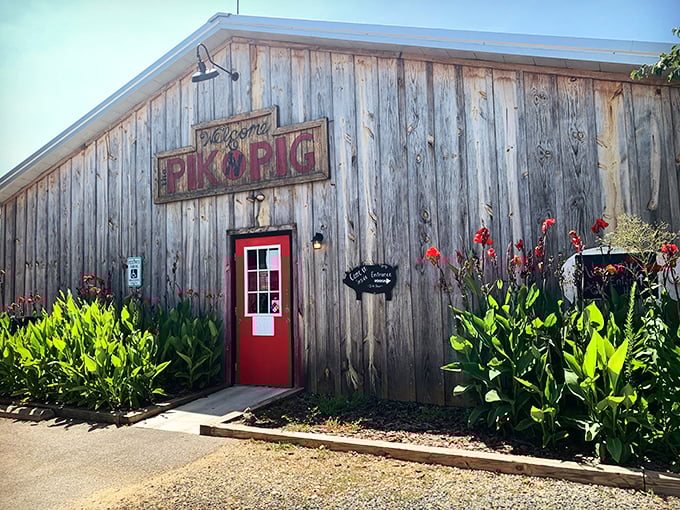The weathered wooden exterior and bright red door of Pik N Pig isn't trying to impress you—it doesn't need to. The smoke wafting through the air does all the talking.