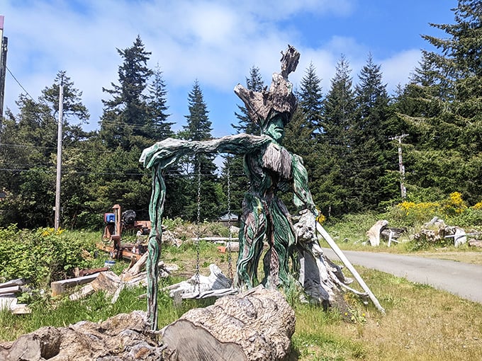 A green sentinel rises from the forest floor, arms outstretched as if to welcome wanderers into this woodland realm of imagination.