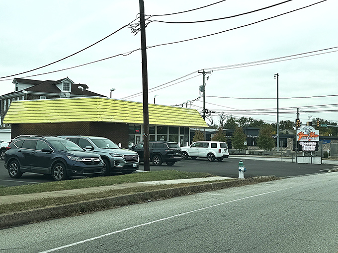 The iconic yellow roof of Yum Yum Bake Shops stands out like a beacon of sweetness, promising donut nirvana to all who approach.